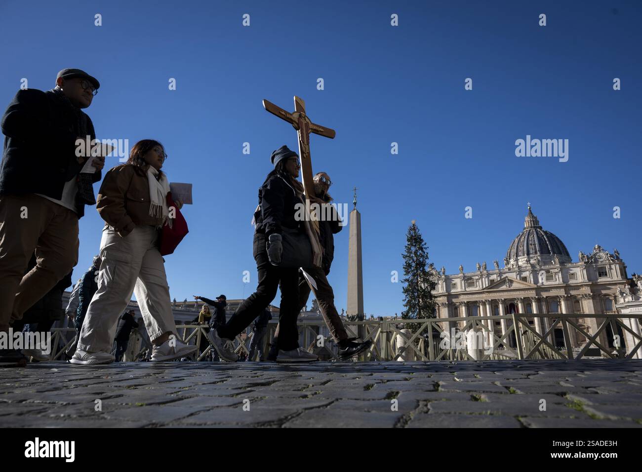 Pilgrims carrying a cross to St. Peter's basilica during the Catholic ...