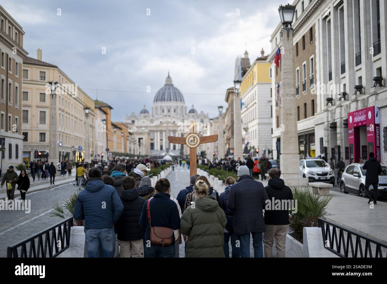 Pilgrims carry a cross on the via della Concillazione which leads to ...