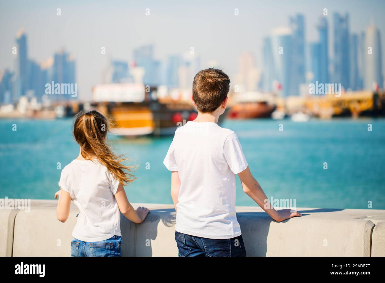 Kids brother and sister enjoying panoramic view of Doha Qatar skyline ...