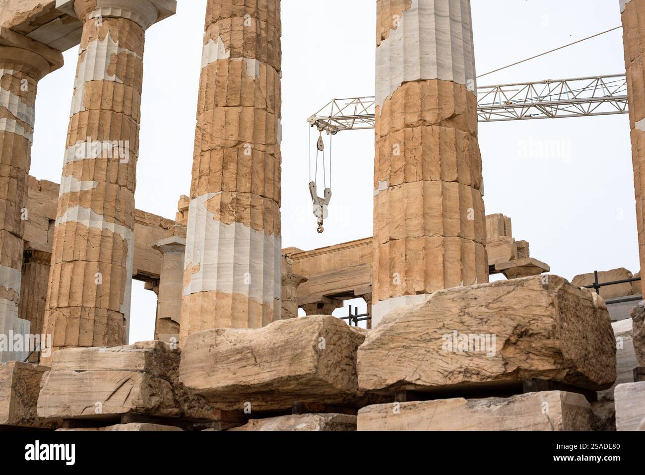 View of construction crane between Doric columns during archaeological renovation and ...