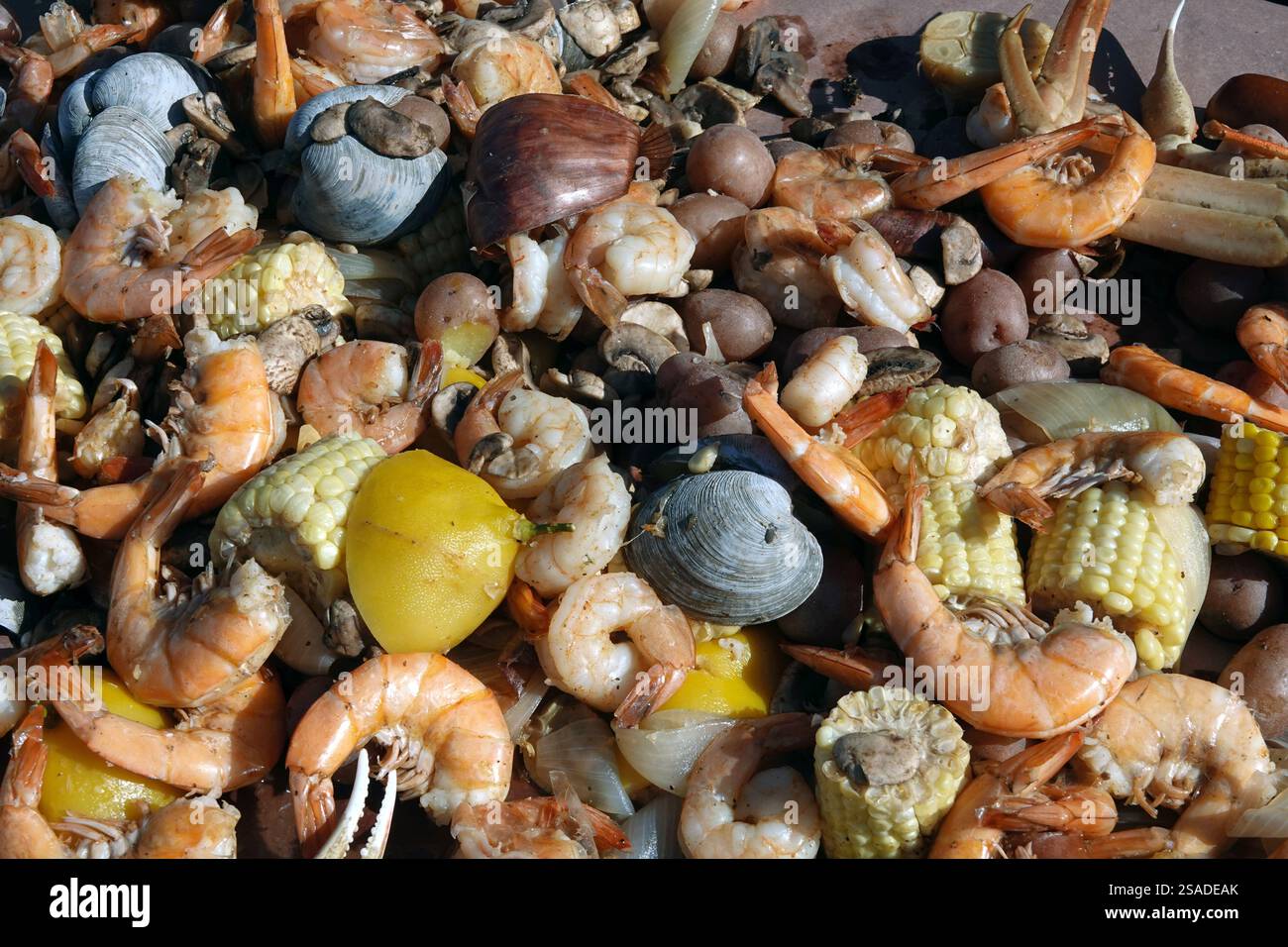 A seafood boil of shellfish including crab and shrimp mixed with ...