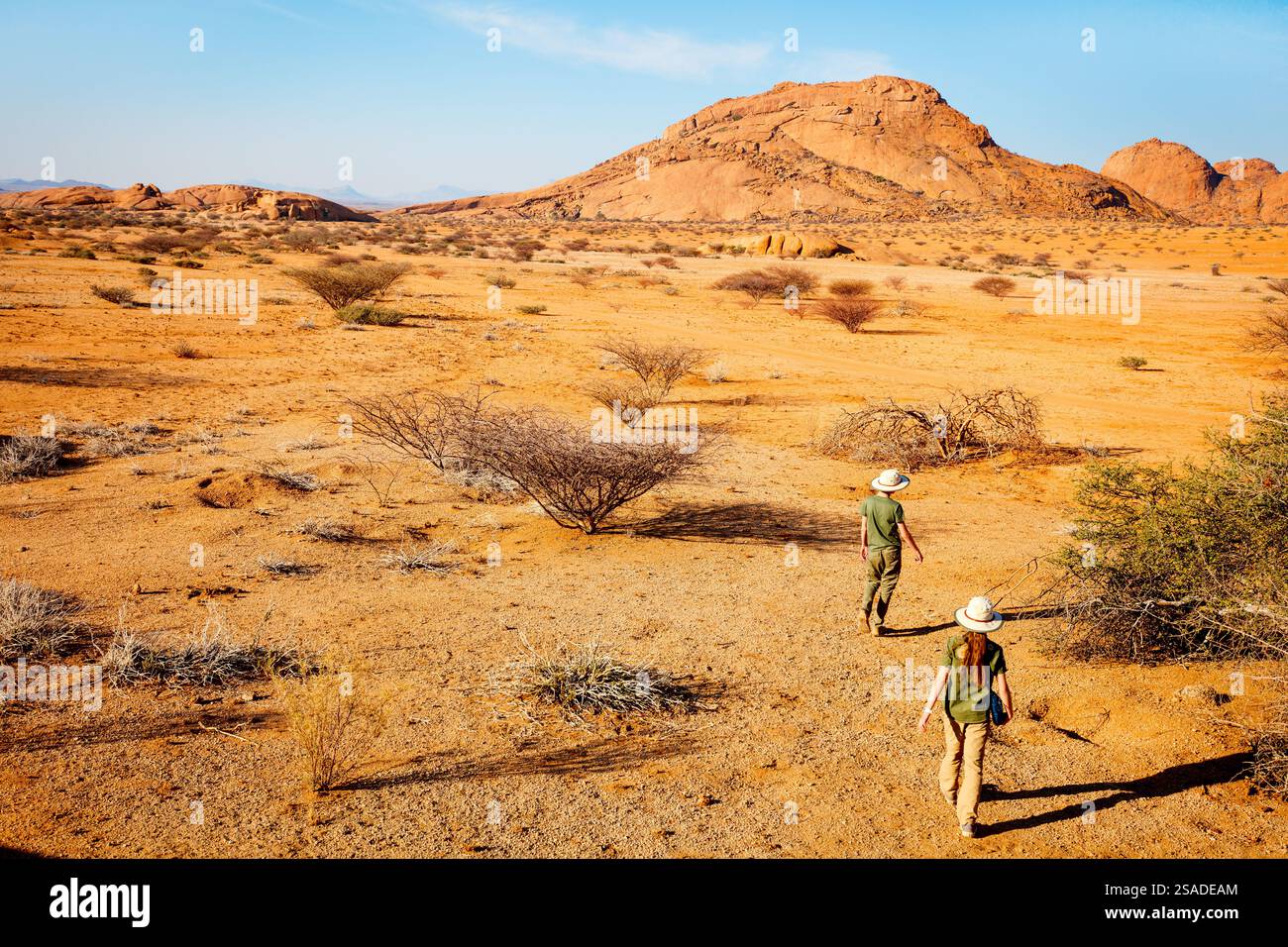 Kids brother and sister hiking in Spitzkoppe with unique rock formations in Damaraland Namibia ...