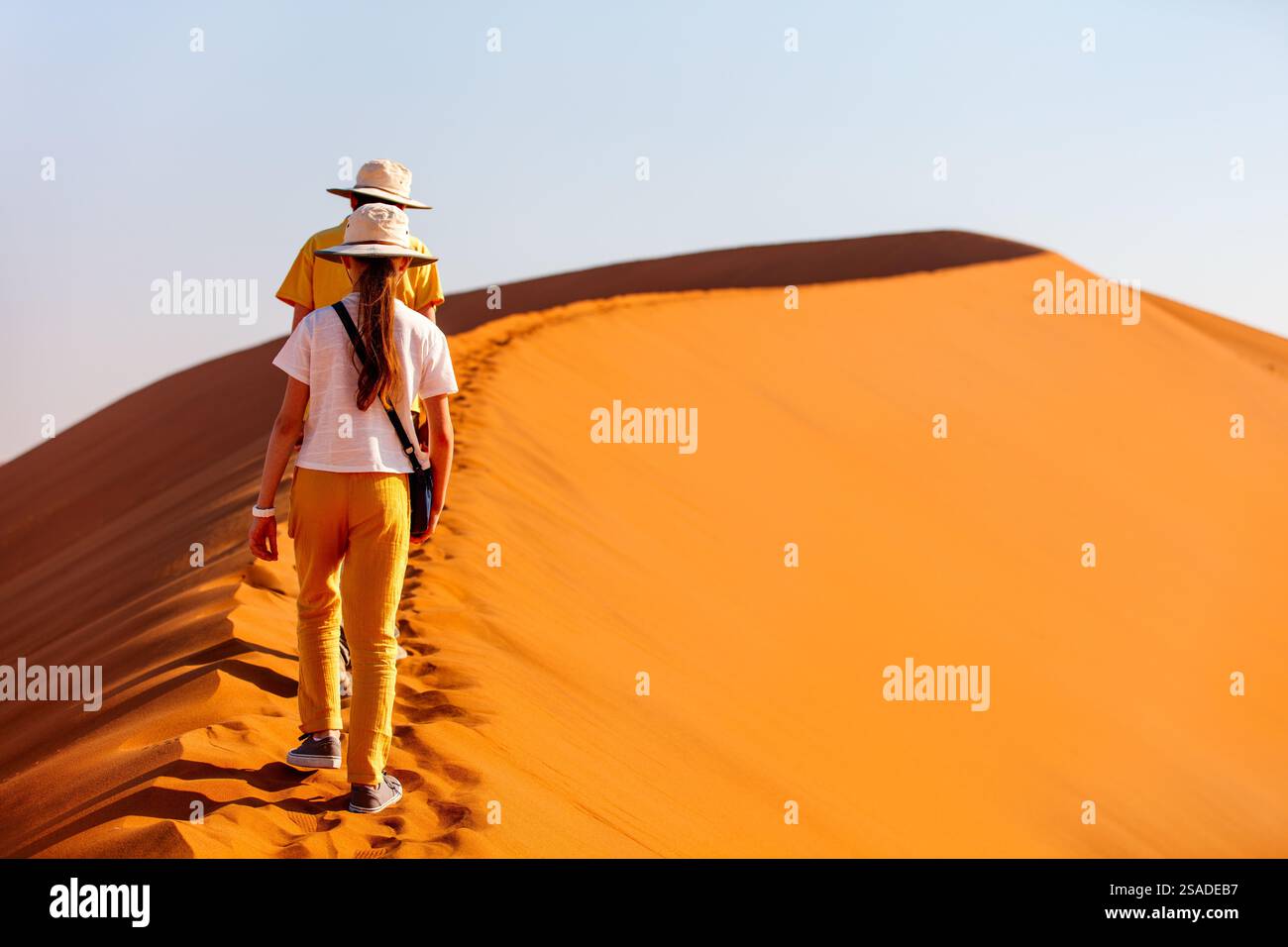 Kids brother and sister climbing up famous red sand dune Big Daddy in ...