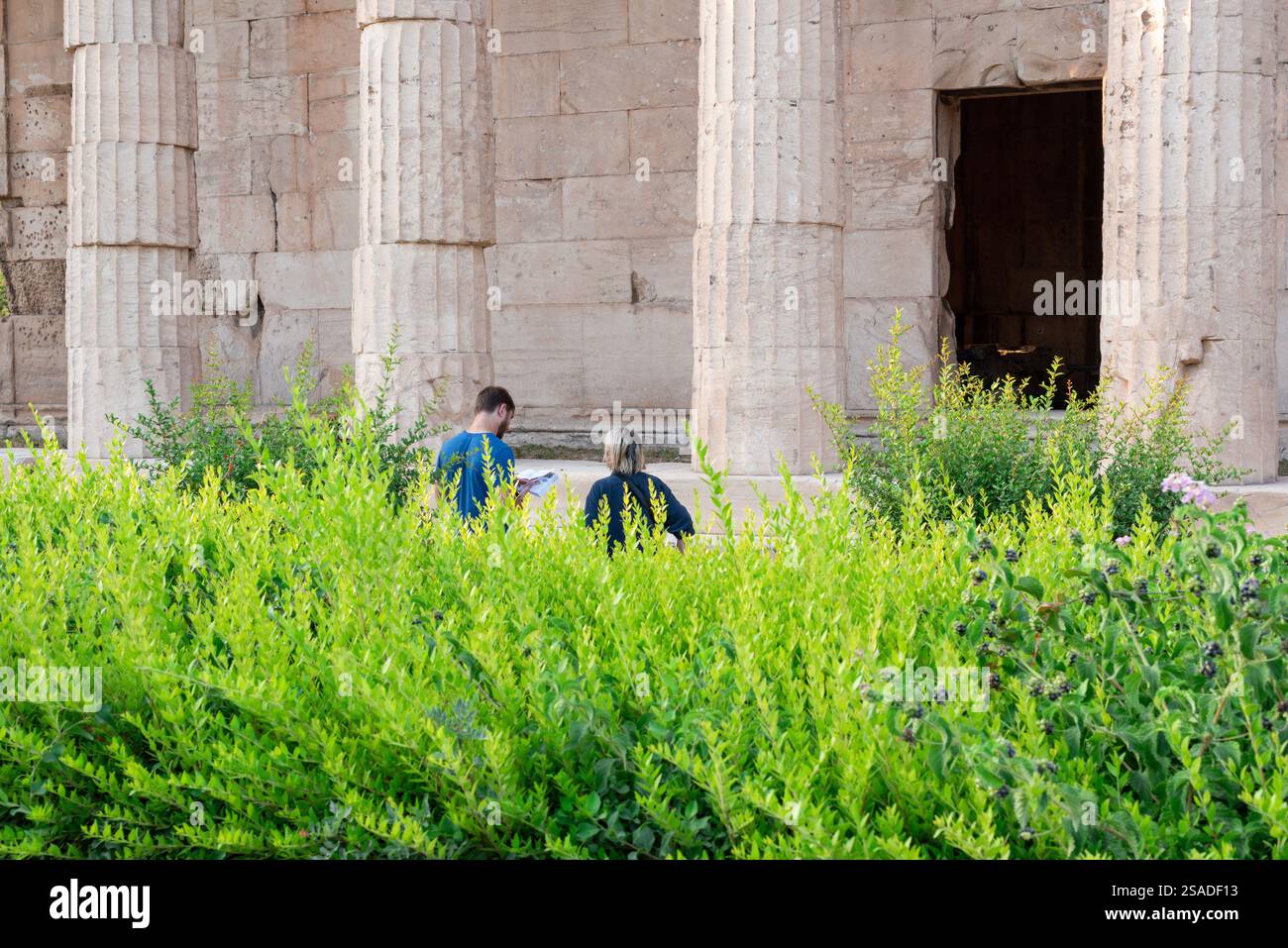 Tourists in front of Doric colonnade of Temple of Hephaestus, in ...