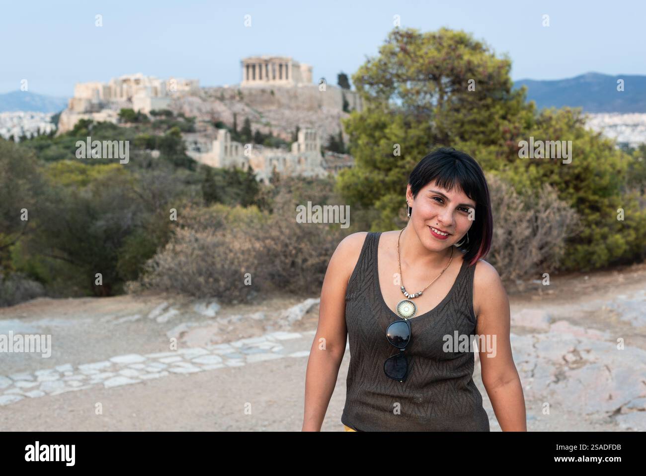 Athens Acropolis with Parthenon temple from the Philopappos hill with beautiful woman smiling ...