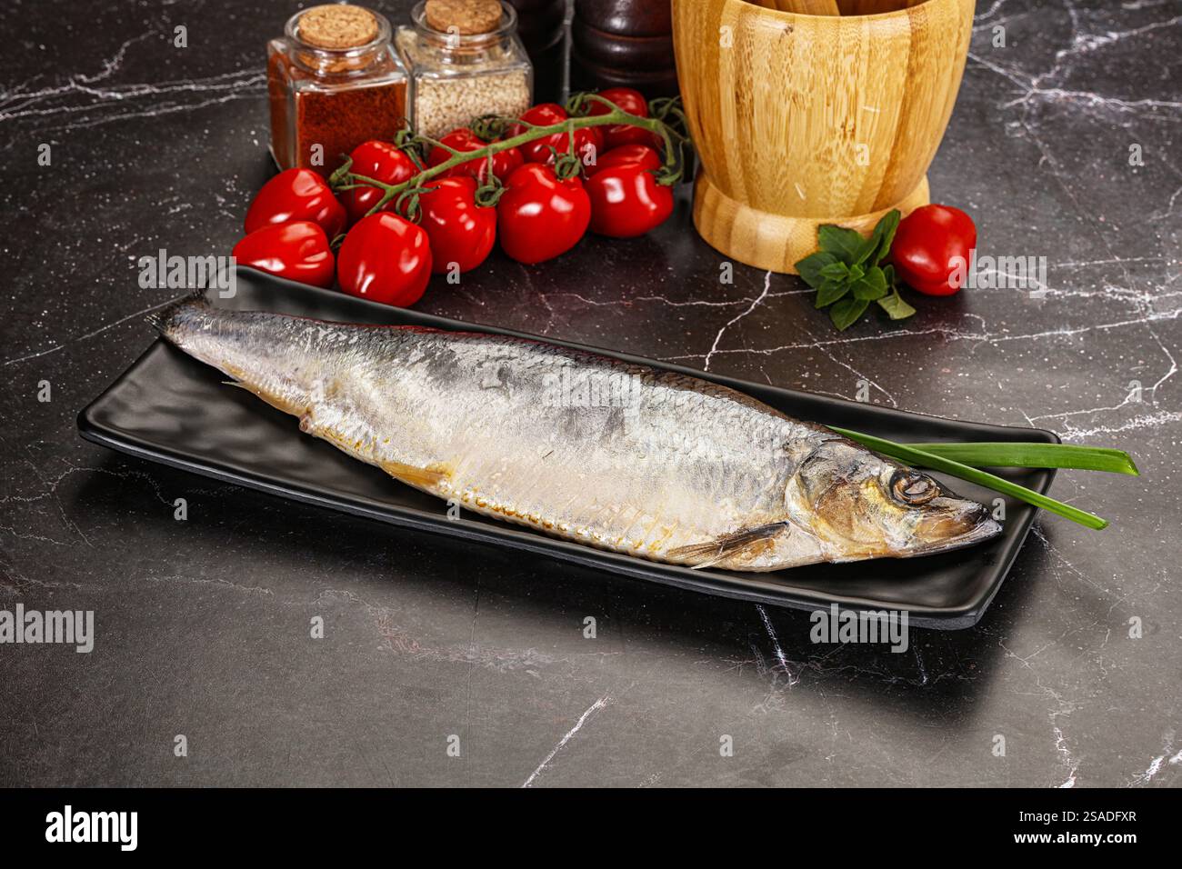 Whole raw salted herring fish in the plate Stock Photo - Alamy