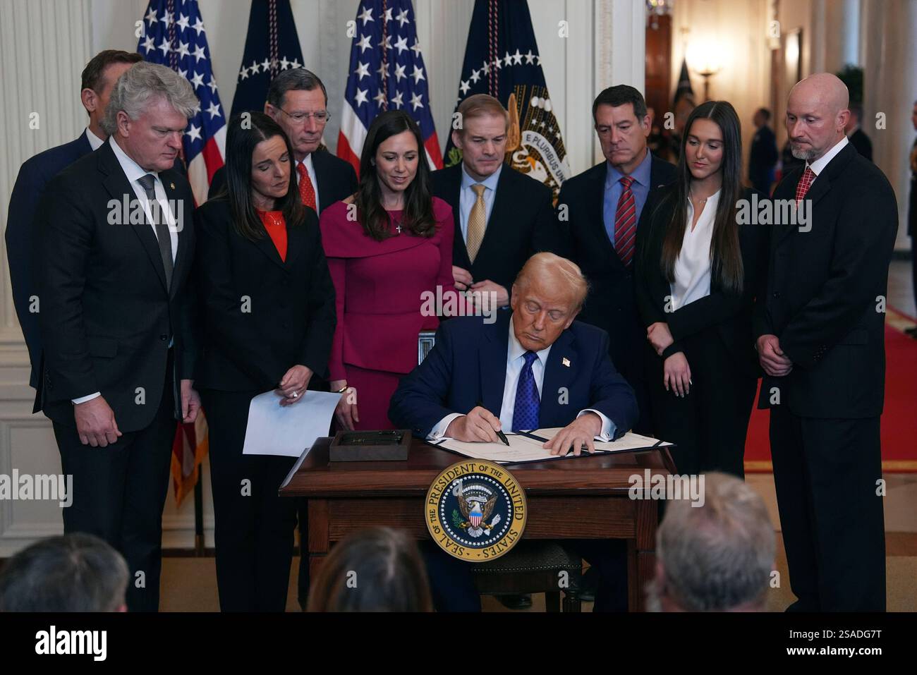 President Donald Trump signs the Laken Riley Act during an event in the ...