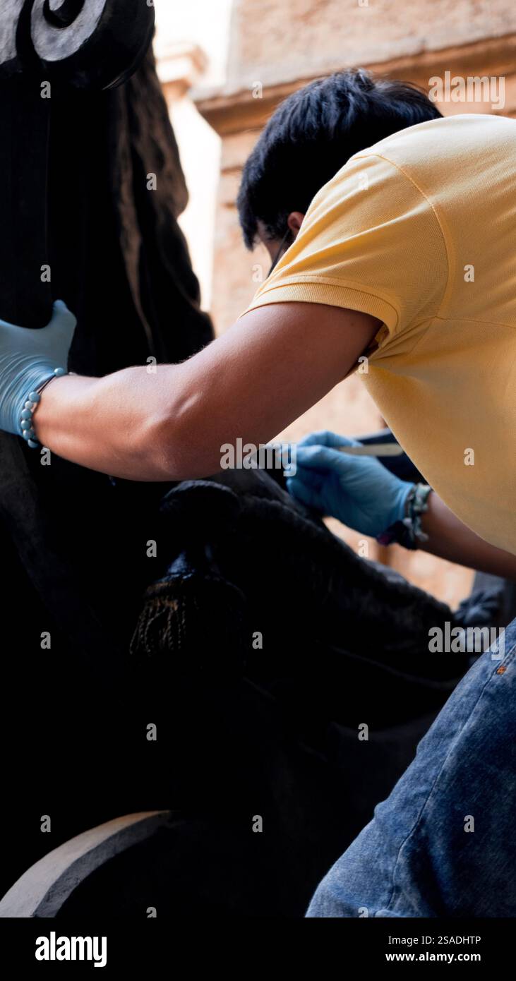 Close-up of male restoring a piece of bronze, back view. Conservation ...