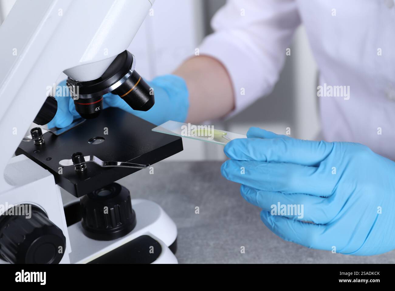 Laboratory testing. Scientist examining sample on slide under ...