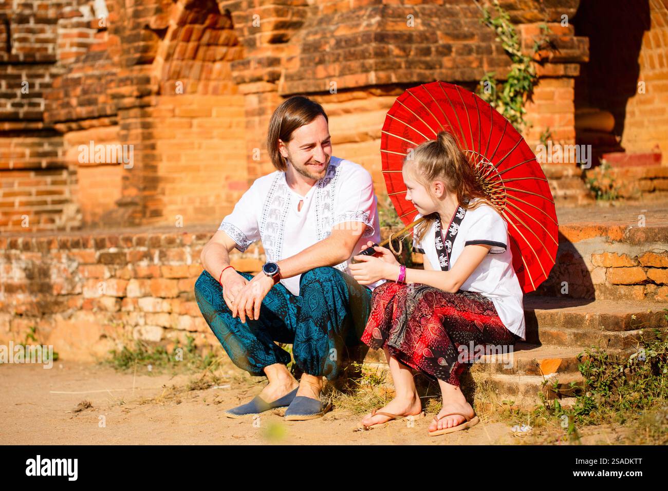 Family of father and daughter visiting ancient temples in Bagan ...