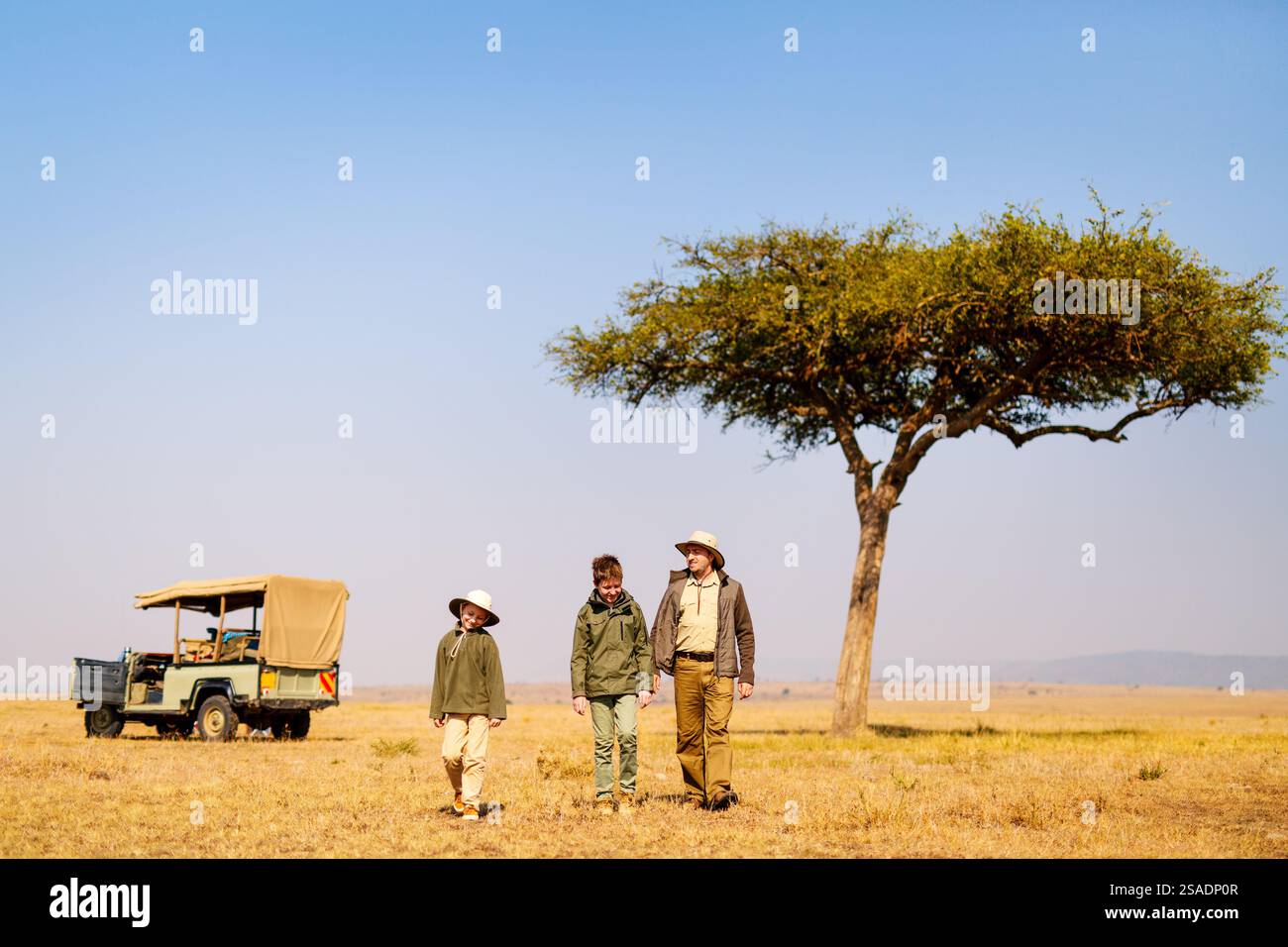 Family of father and kids on African safari vacation enjoying morning ...