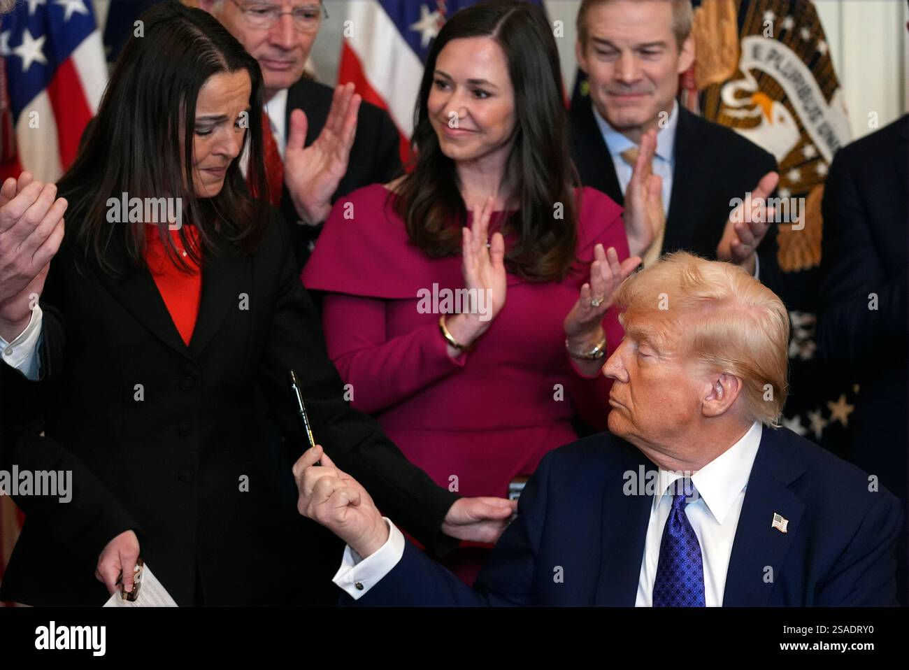 President Donald Trump hands a pen to Allyson Phillips, mother of Laken ...