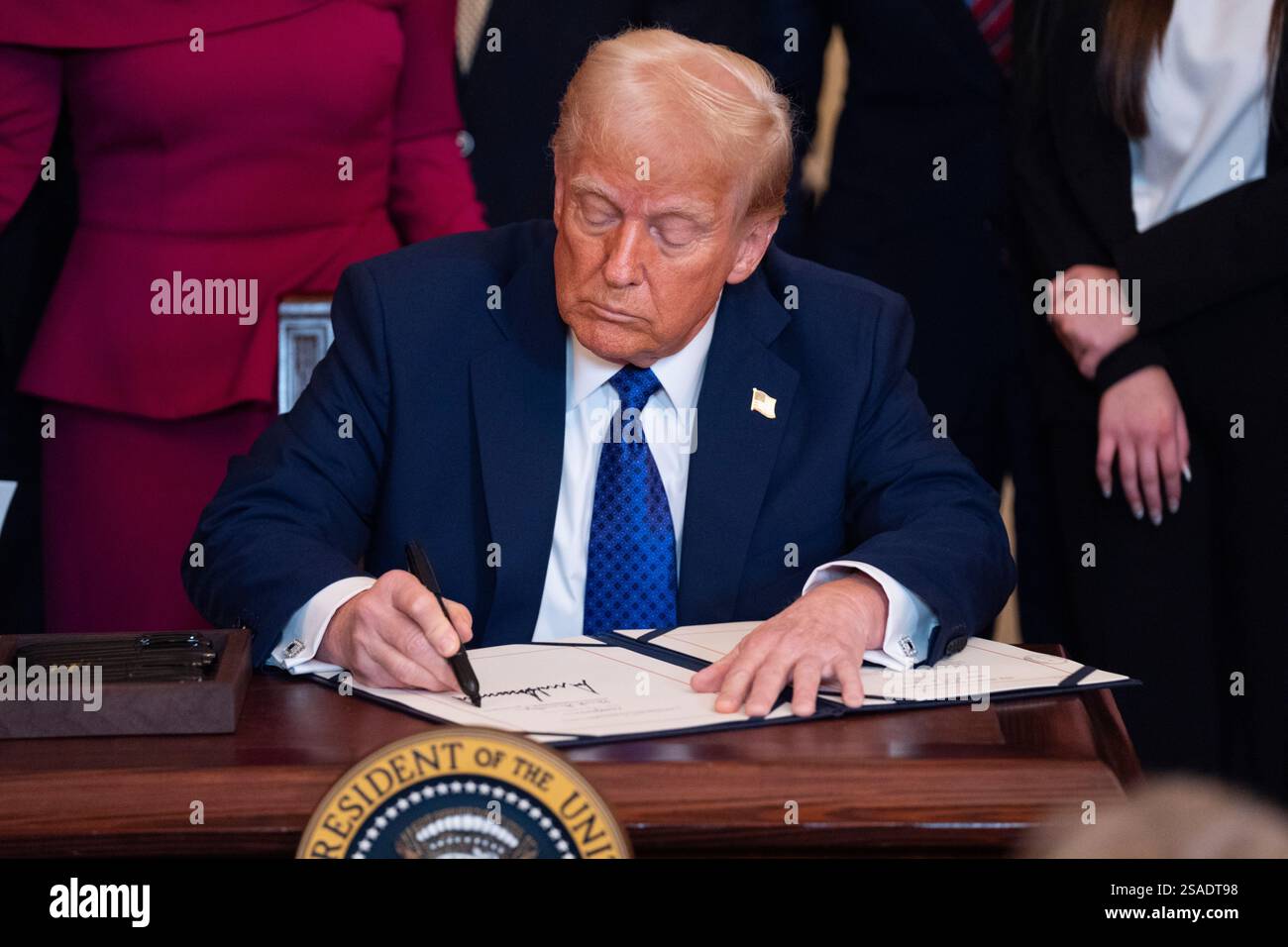 President Donald Trump signs the Laken Riley Act during in the East ...