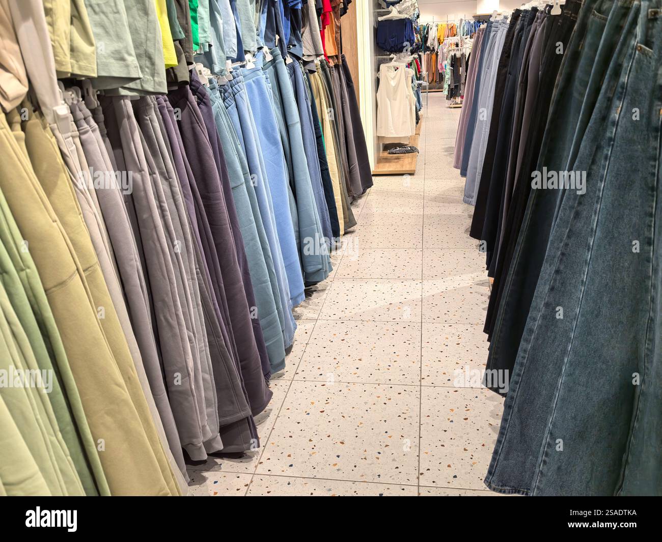 Vibrant clothing store features a neat rack showcasing various denim ...