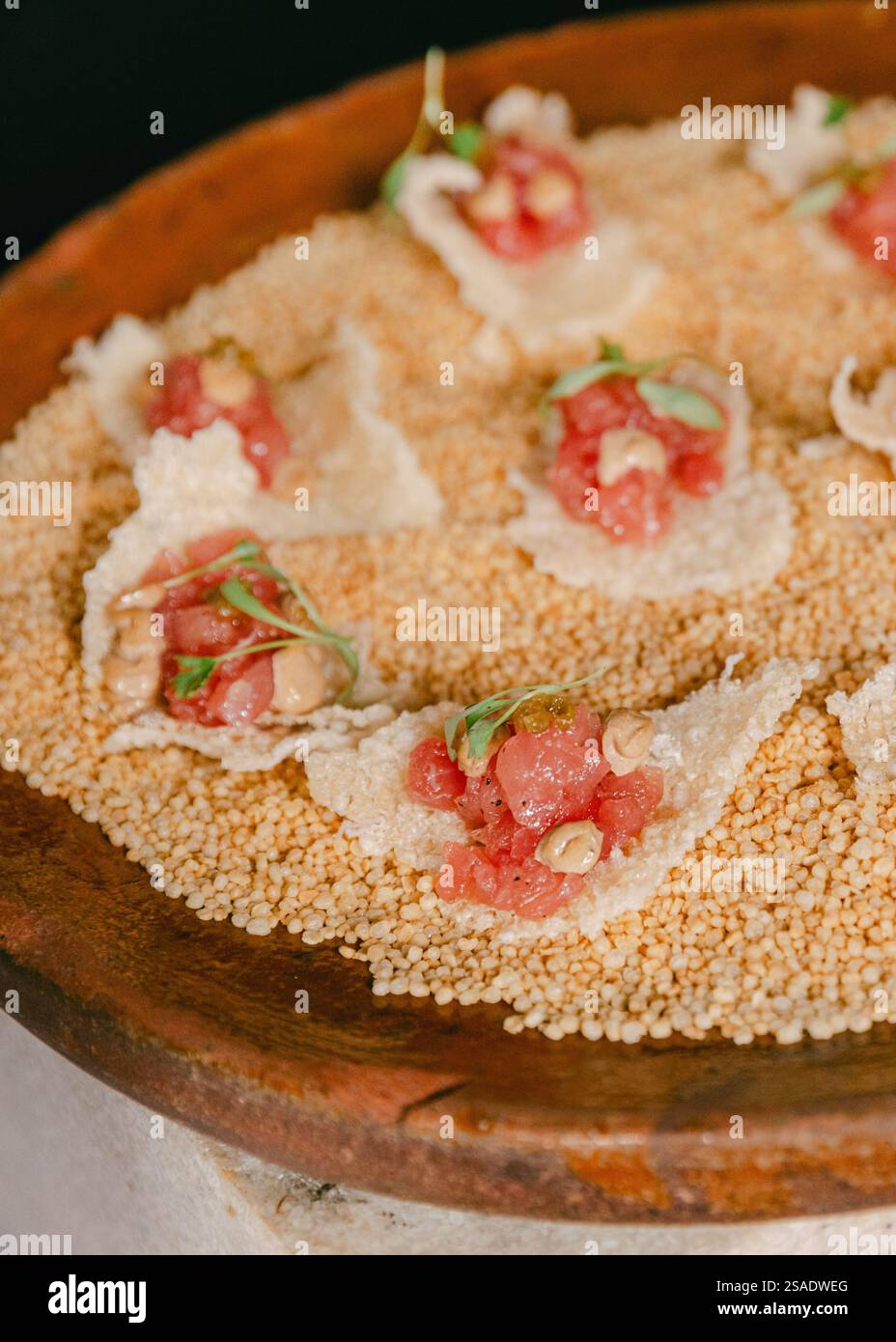 A wooden platter showcases beautifully arranged seafood appetizers made ...