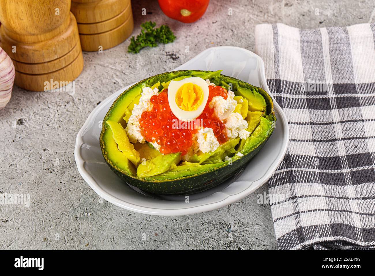 Avocado with red caviar and quil egg and soft cheese Stock Photo - Alamy