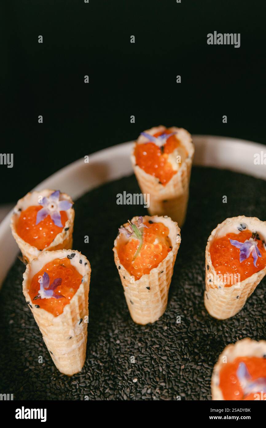 Delicate seafood cones filled with vibrant orange roe and topped with ...