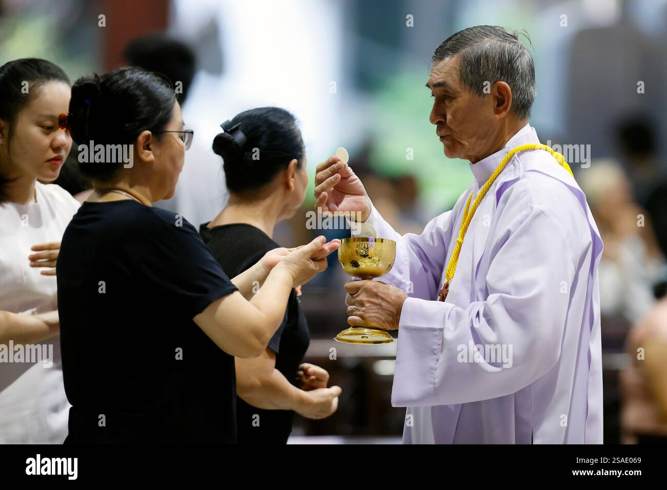 Tan Hoa Church. Sunday catholic mass. Priest giving holy communion. Ho ...