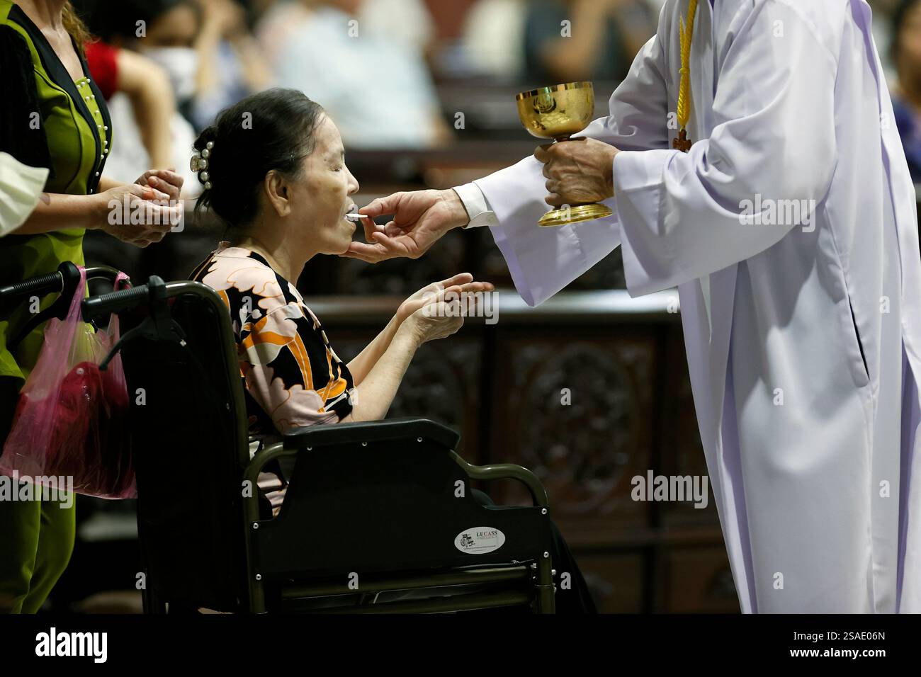 Tan Hoa Church. Sunday catholic mass. Priest giving holy communion. Ho ...