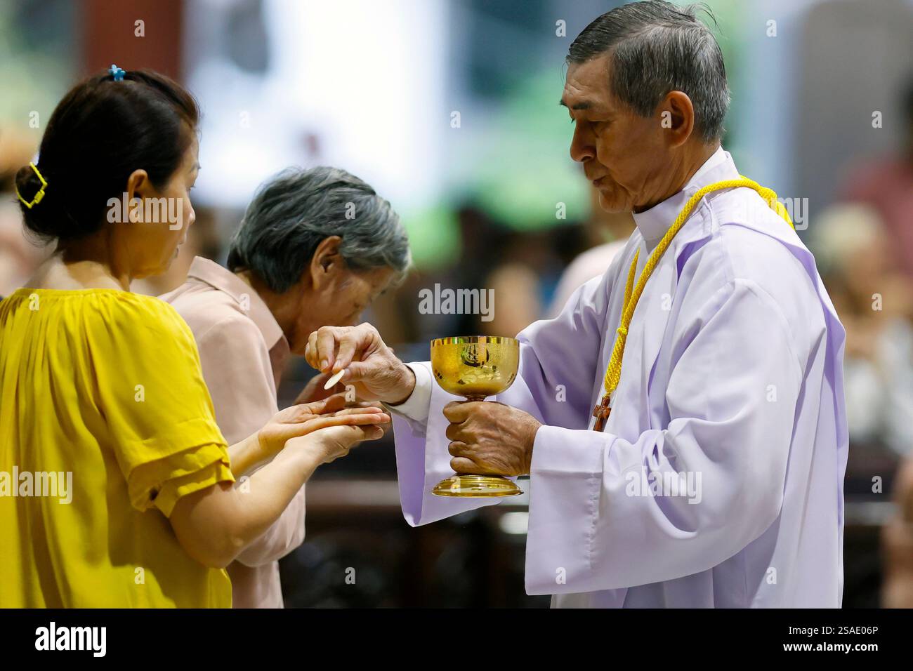 Tan Hoa Church. Sunday catholic mass. Priest giving holy communion. Ho ...