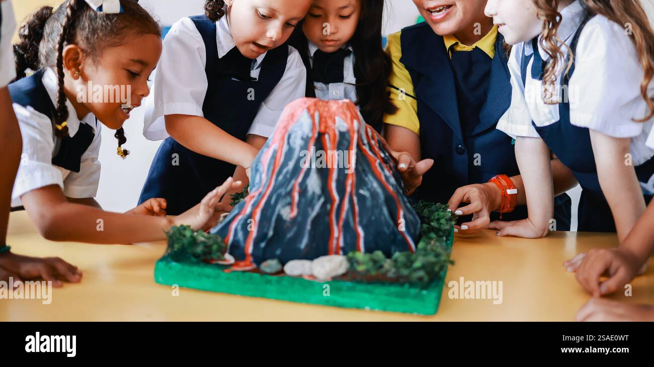 Teacher and group of children learning about volcanos at science ...