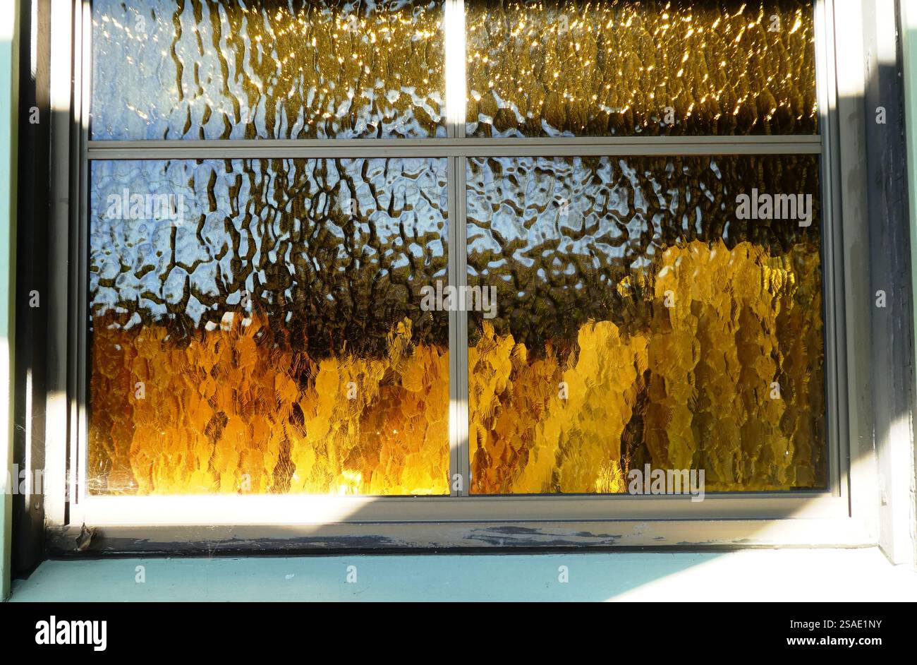 Objects behind ornate windows with golden textured glass panes in the ...
