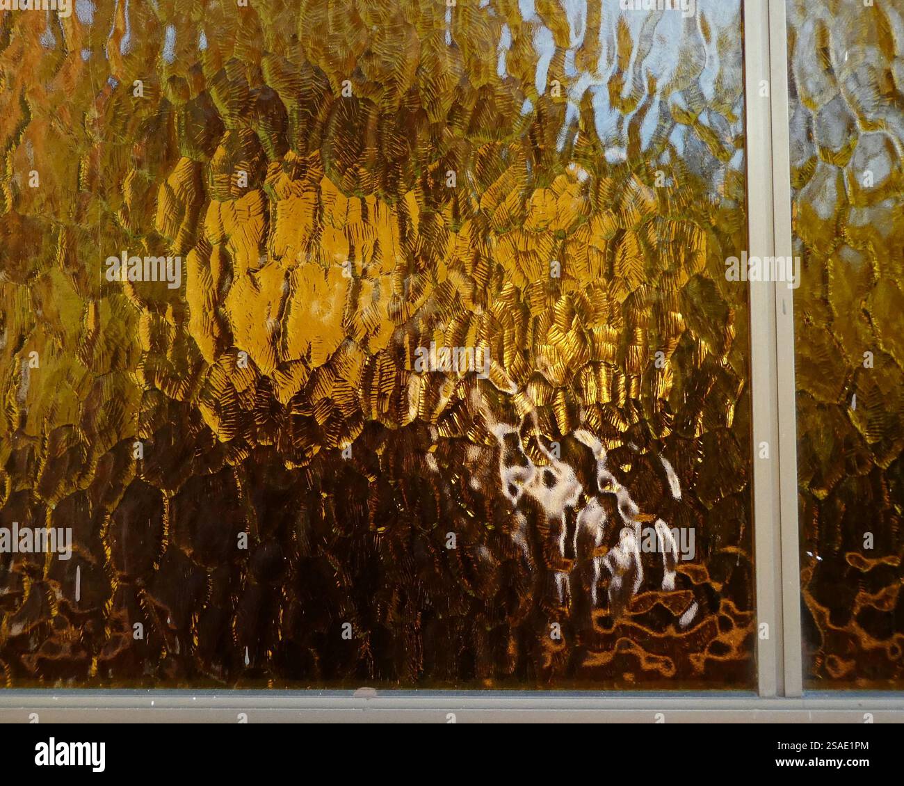 Objects behind ornate windows with golden textured glass panes in the ...