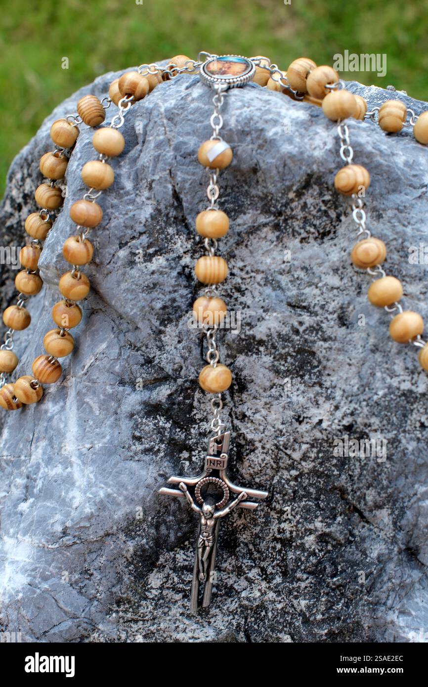Rosary on a rock. Symbol of strength and eternity. Catholic church ...