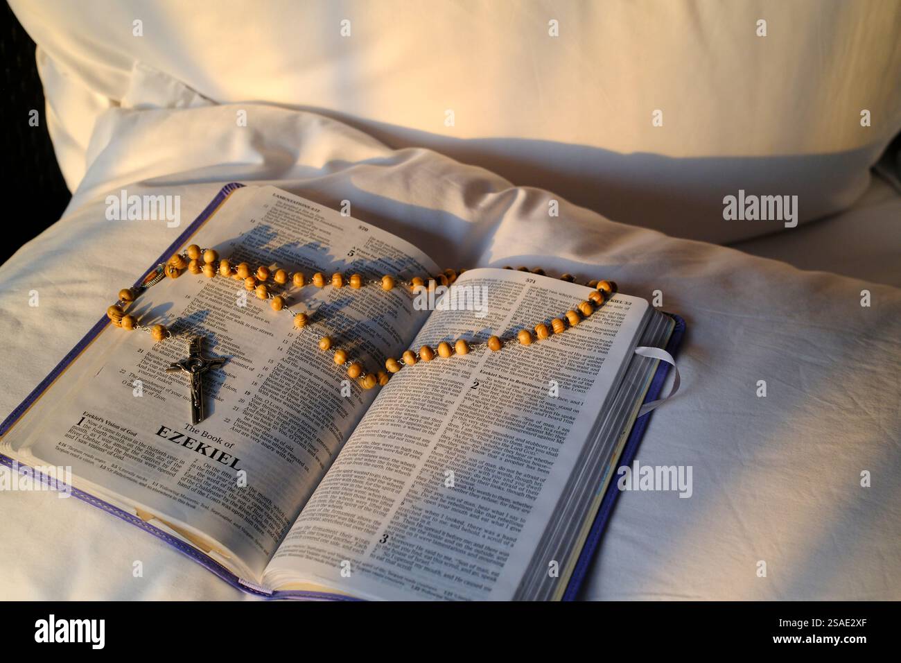 Pray at home. Bible and Rosary on a bed Stock Photo - Alamy