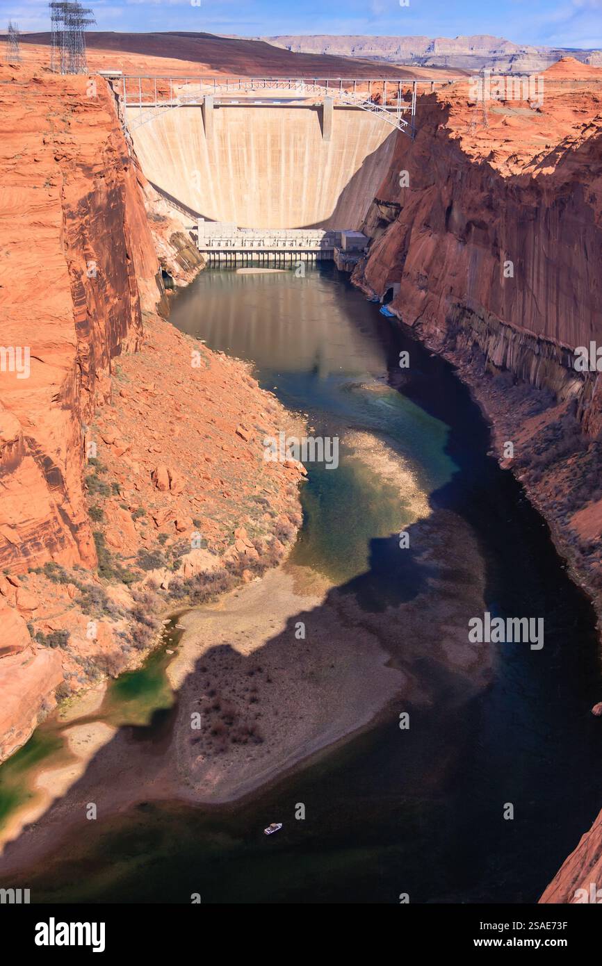 A river with a dam in the background. The water is green and the rocks ...