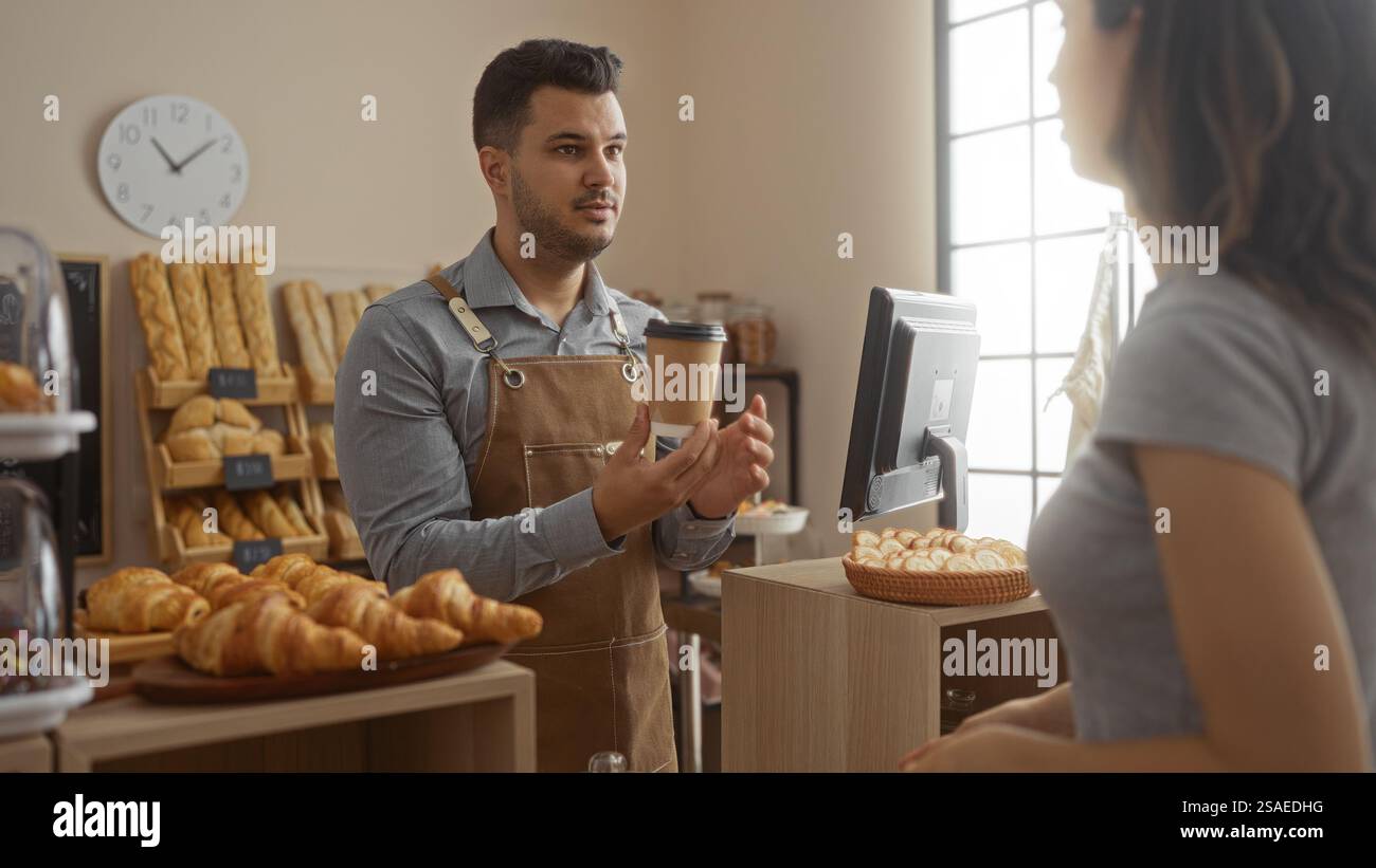 Man serving a woman coffee in a bakery with bread and pastries on ...