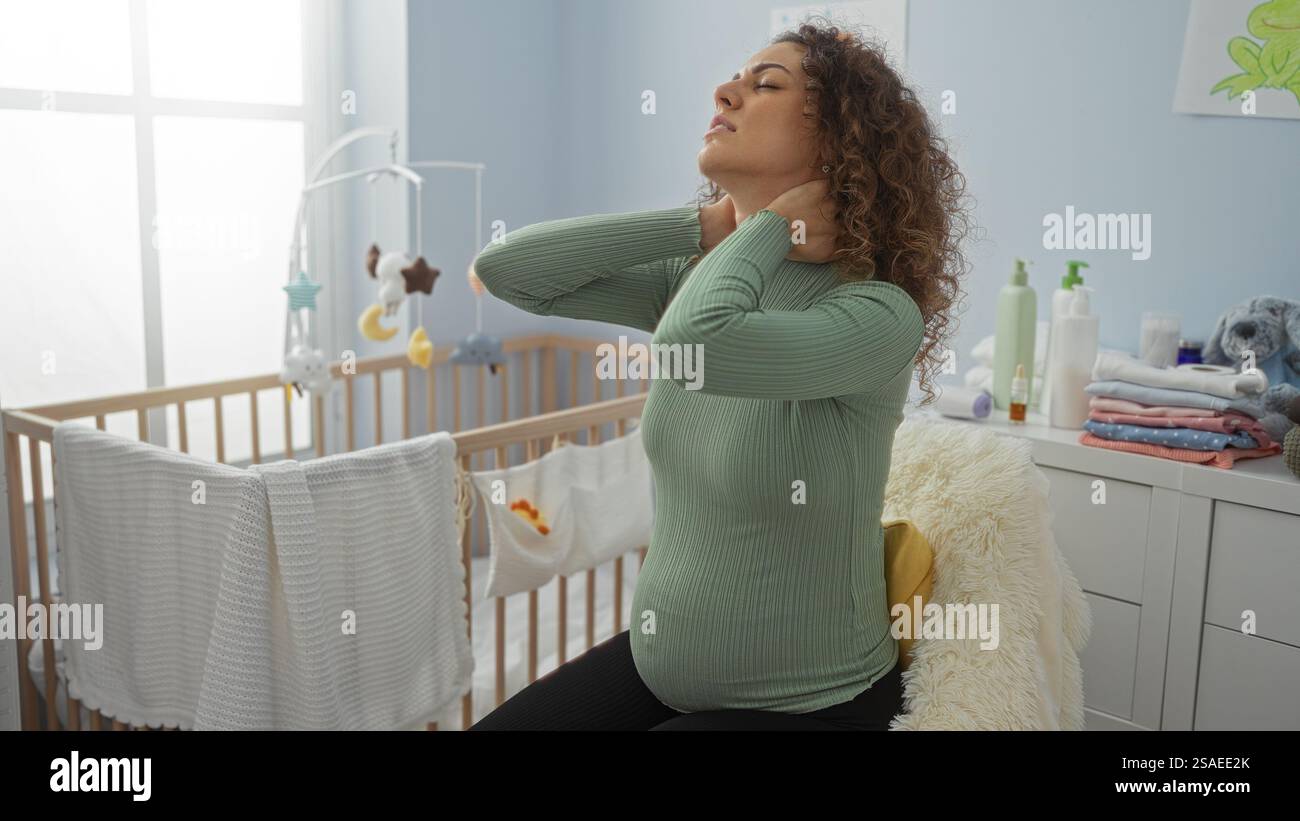 Woman sitting in a bedroom holding her neck, showing discomfort, with a ...
