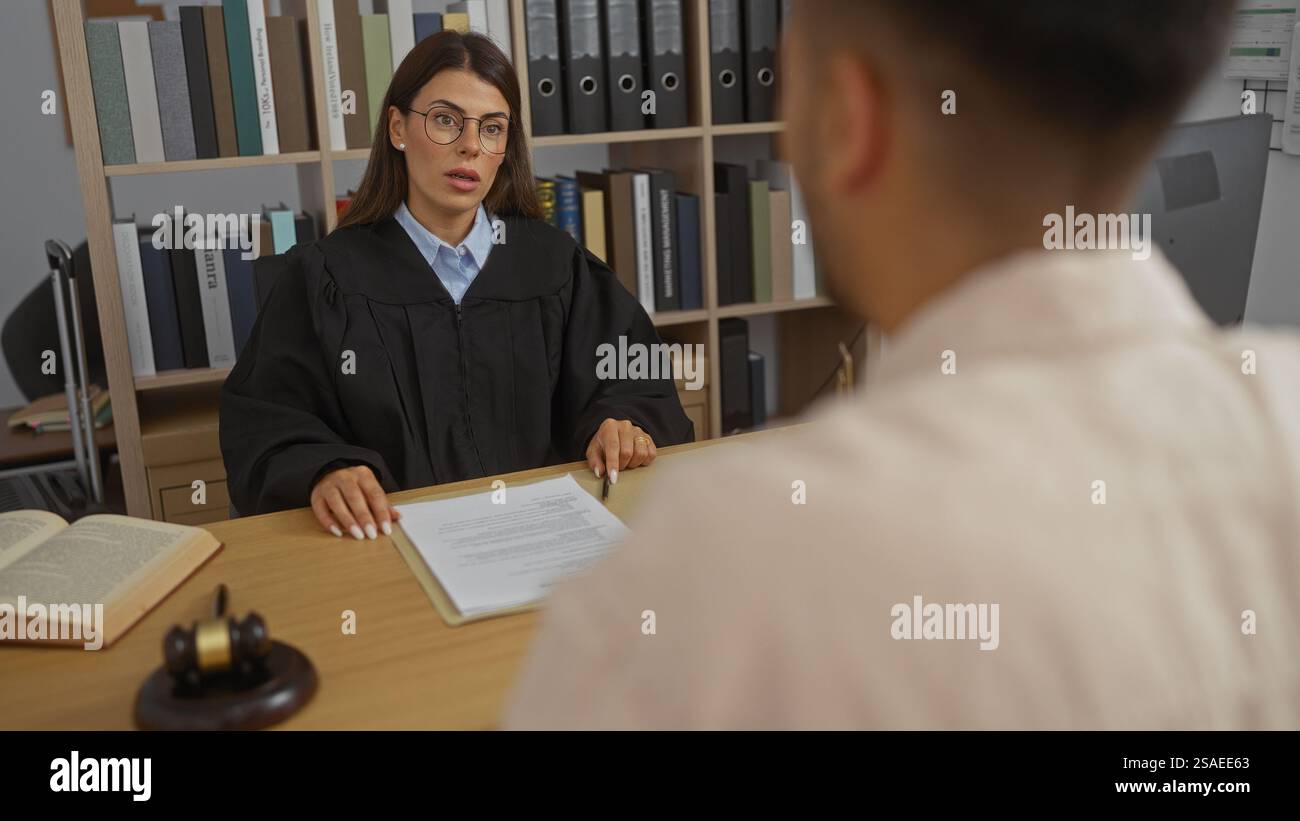Woman in judge robe conversing with man across desk in office interior ...
