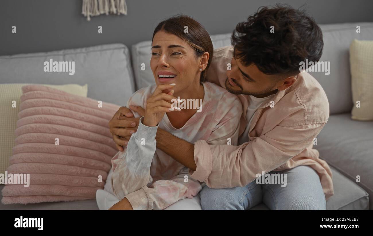 Woman crying comforted by man on couch in cozy living room showing love ...