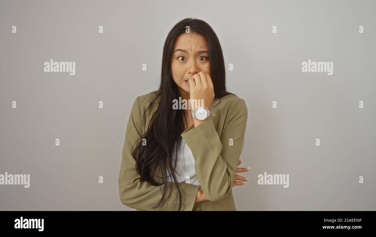 Woman appearing anxious, young, chinese, isolated against white ...