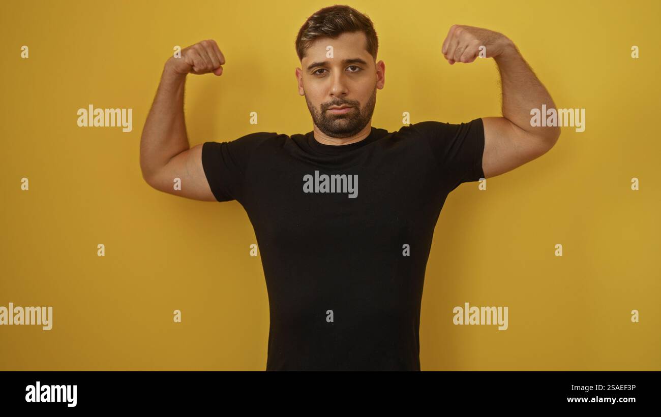 Man flexing his muscles in a confident pose against a vibrant yellow ...