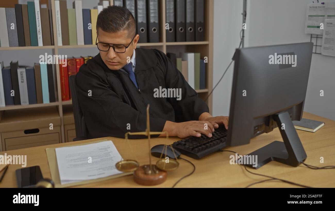 Hispanic man in office working on a computer wearing judge robes ...