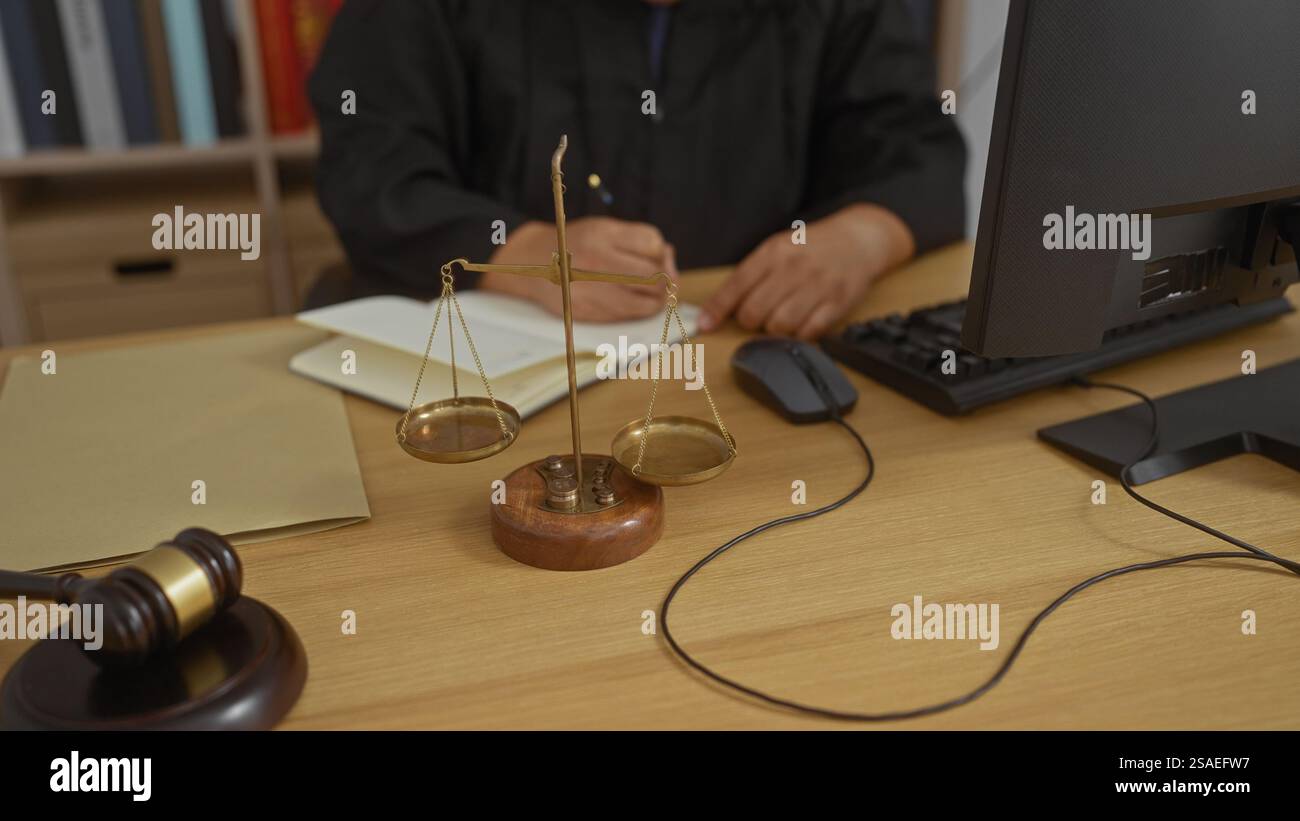 Male judge in office writing notes with a gavel and scales on the desk ...