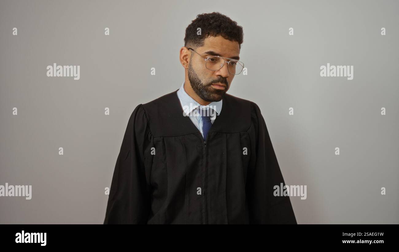 Young man wearing glasses and a black judge robe standing against a ...