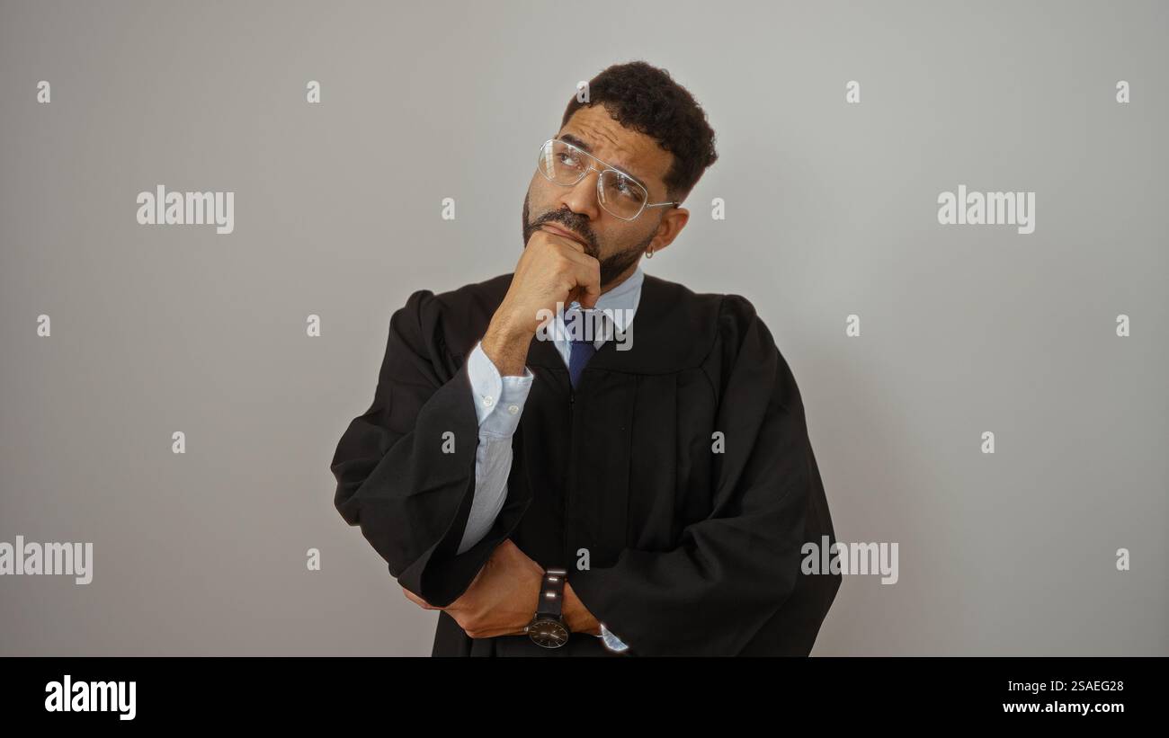 Young hispanic man in a judge robe on isolated white background ...