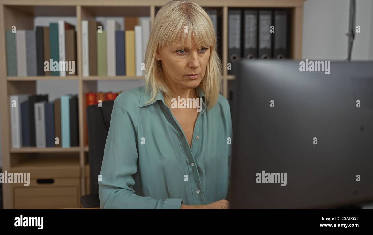 Woman focused at work in an office, surrounded by shelves and books ...