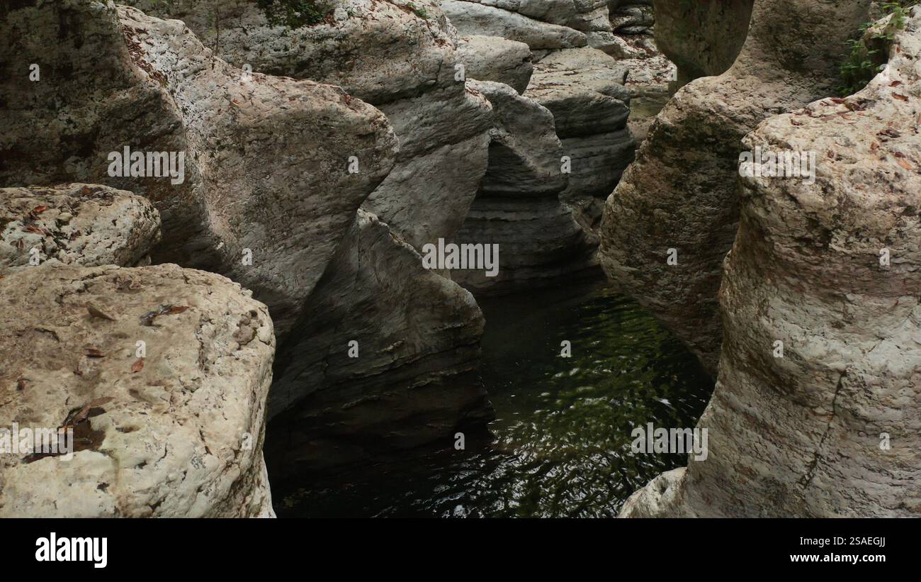 Dark water flows through a narrow canyon carved in the rock, creating a ...