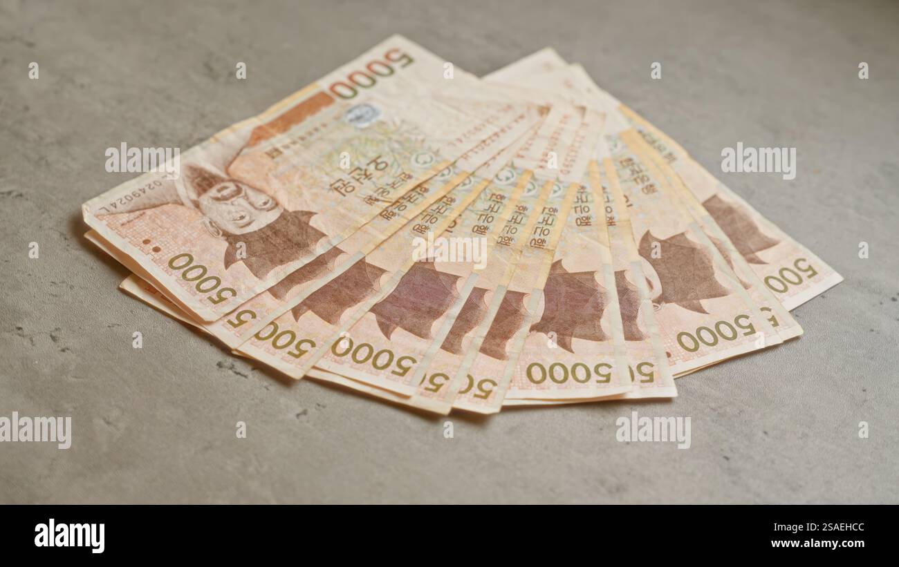 South korean 5000 won banknotes fanned out on a concrete surface ...