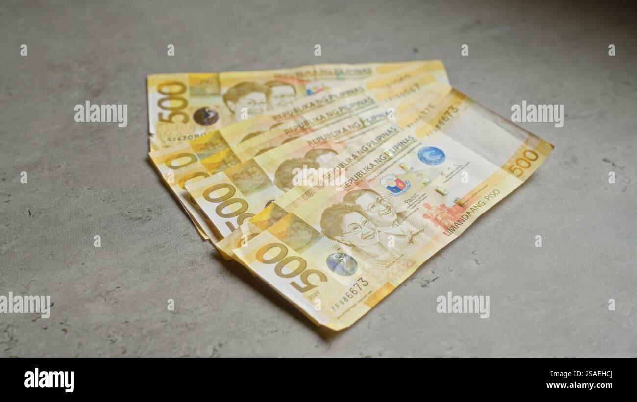 Philippine pesos banknotes on a rough concrete surface illustrating ...