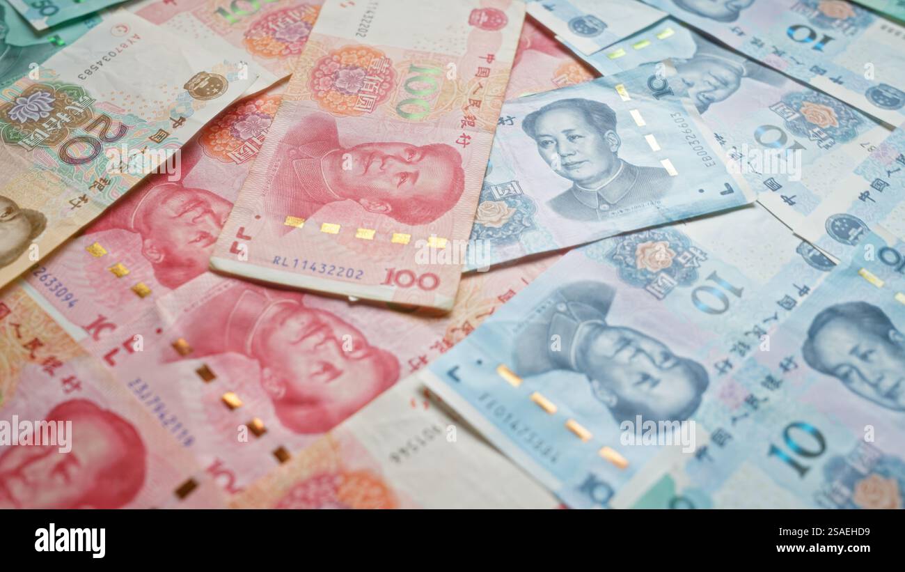 Chinese yuan banknotes scattered on a surface displaying various ...