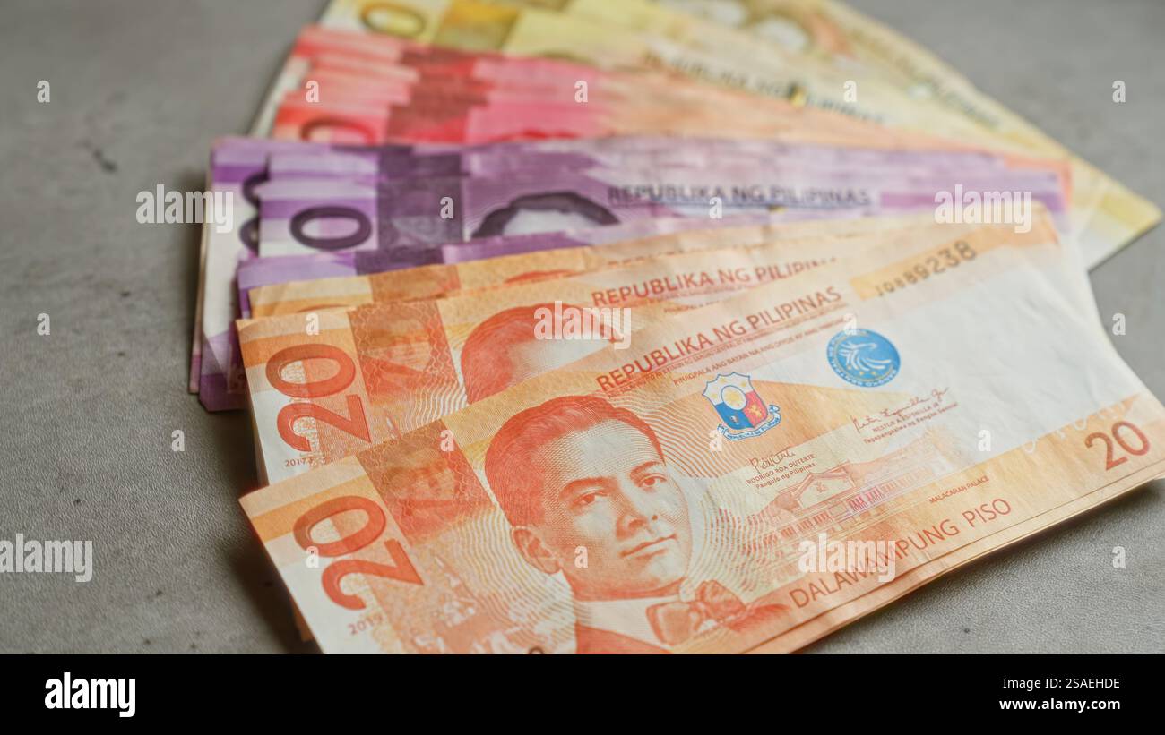 Philippine banknotes in various denominations laid out on a concrete ...