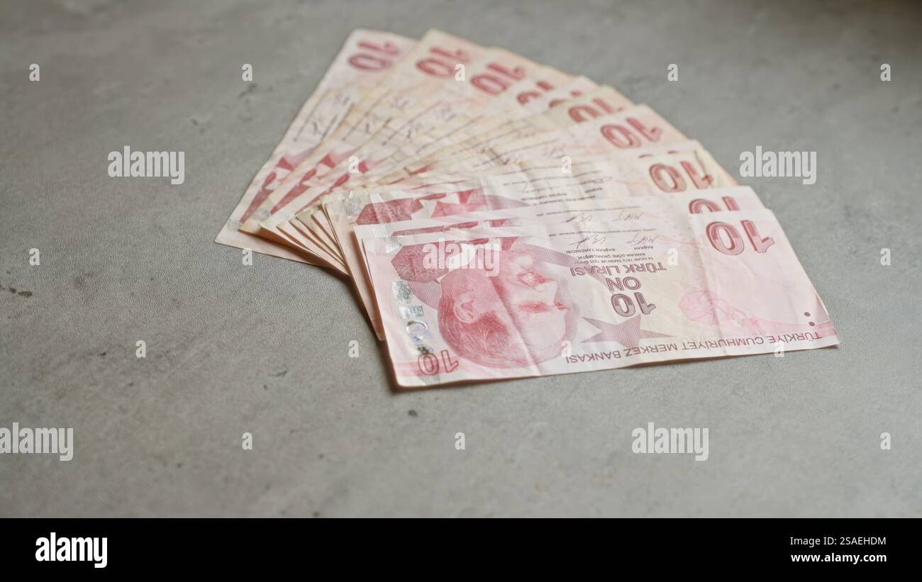 Turkish lira banknotes spread on a concrete surface, depicting the ...