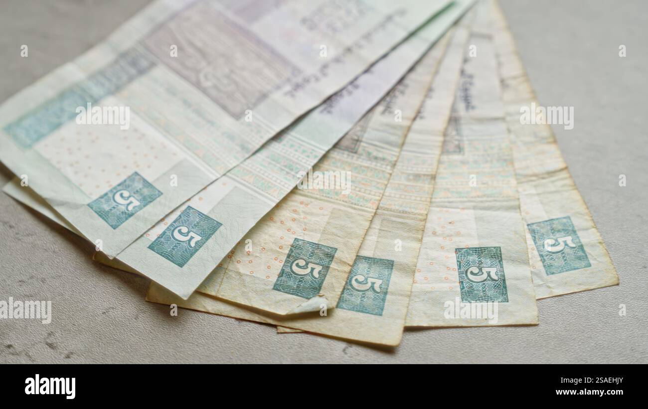 Egyptian banknotes spread out on a concrete surface, showcasing the ...