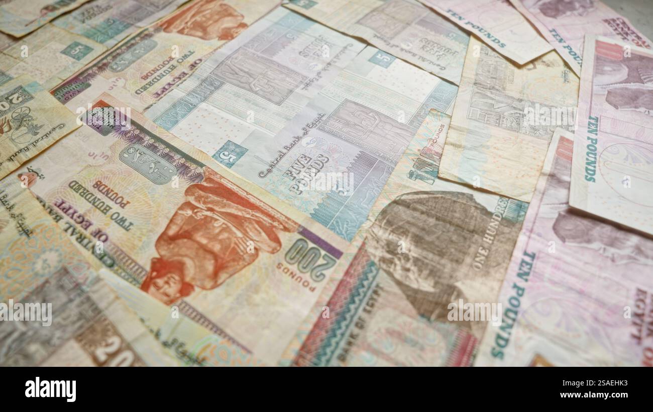 Egyptian banknotes of various denominations scattered, highlighting ...