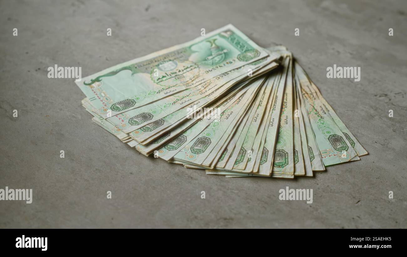 United arab emirates dirham banknotes spread out on a concrete surface ...